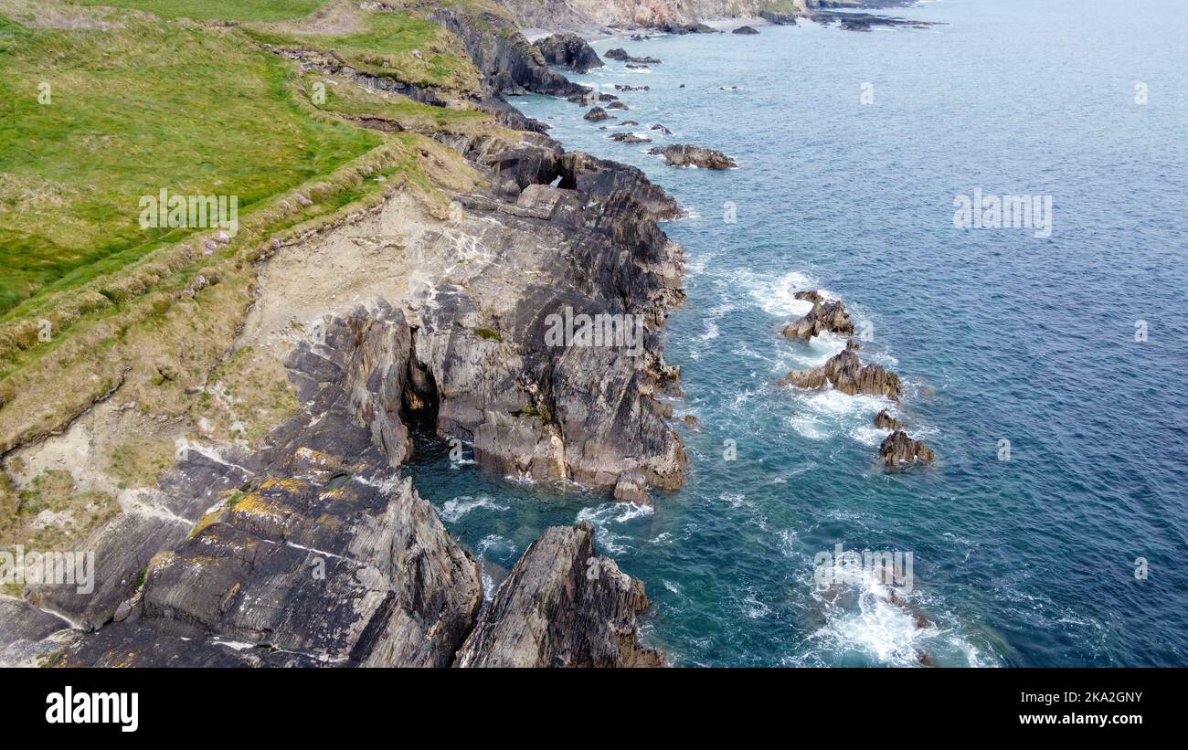 Beautiful sea water near steep coastal cliffs. The nature of Ireland. Dangerous reefs and cliffs ...