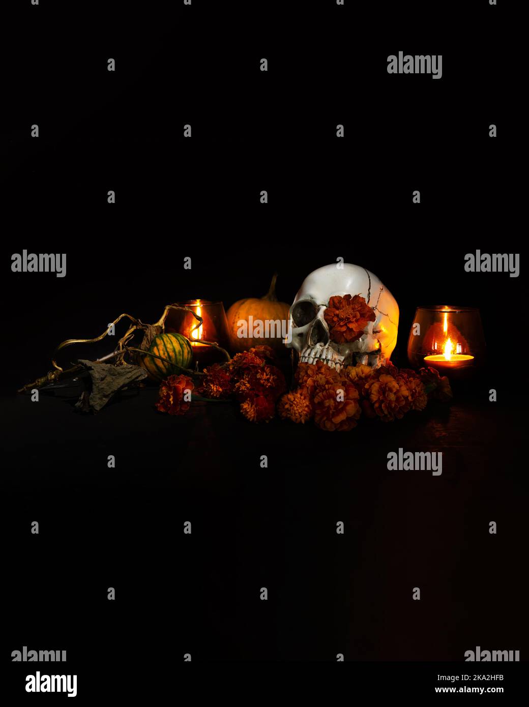 Skull, Burning candles and marigold flowers on black background ...