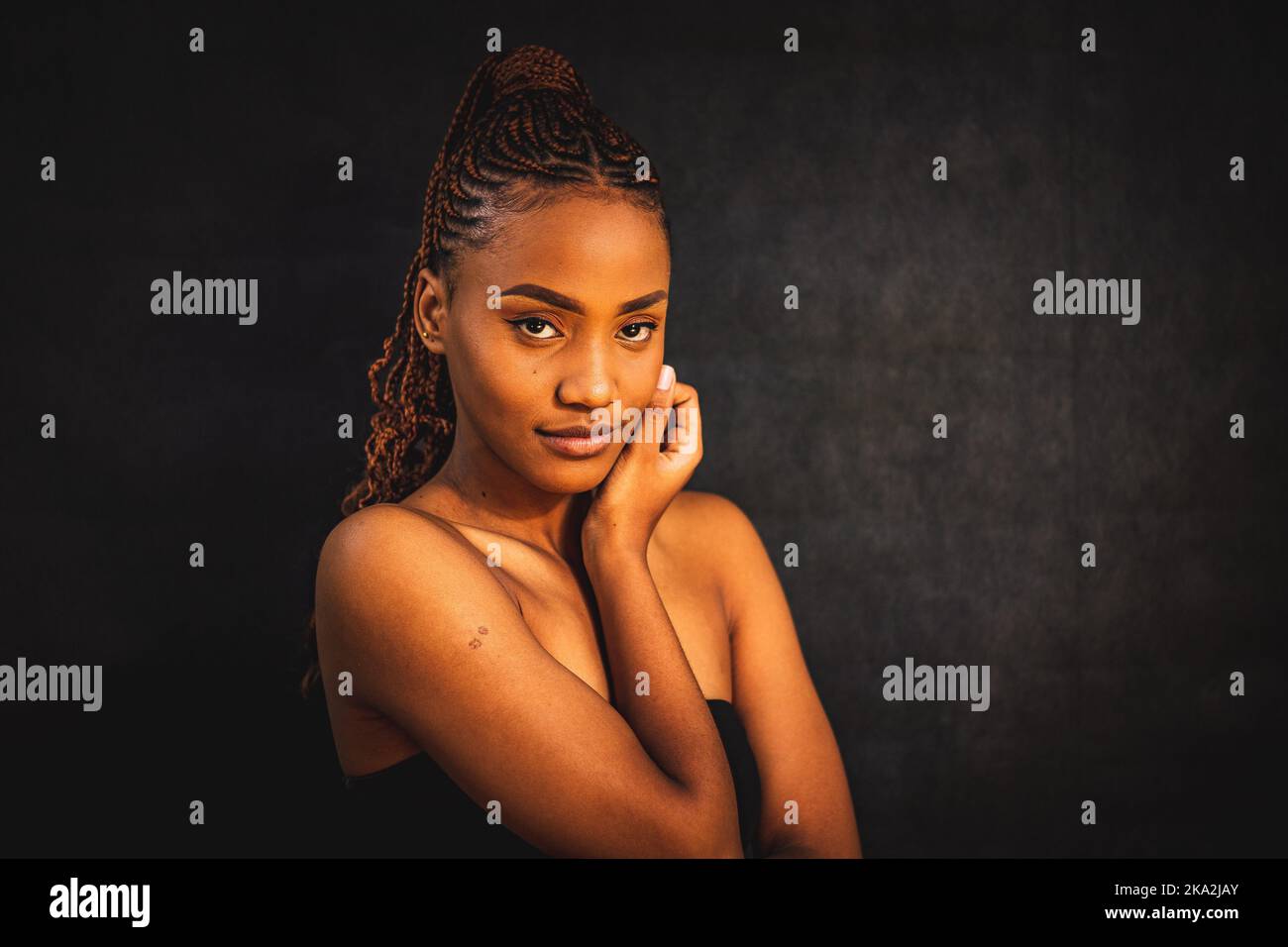 A black, South African teenage girl staring intently into the camera ...