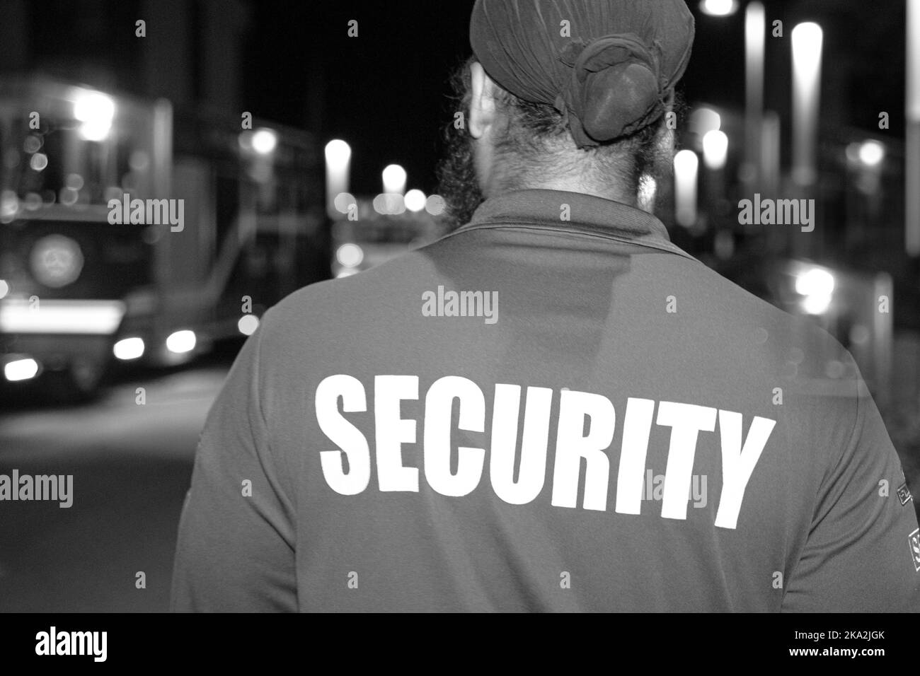 The adult man wearing the blue uniform with the "Security" sign while ...