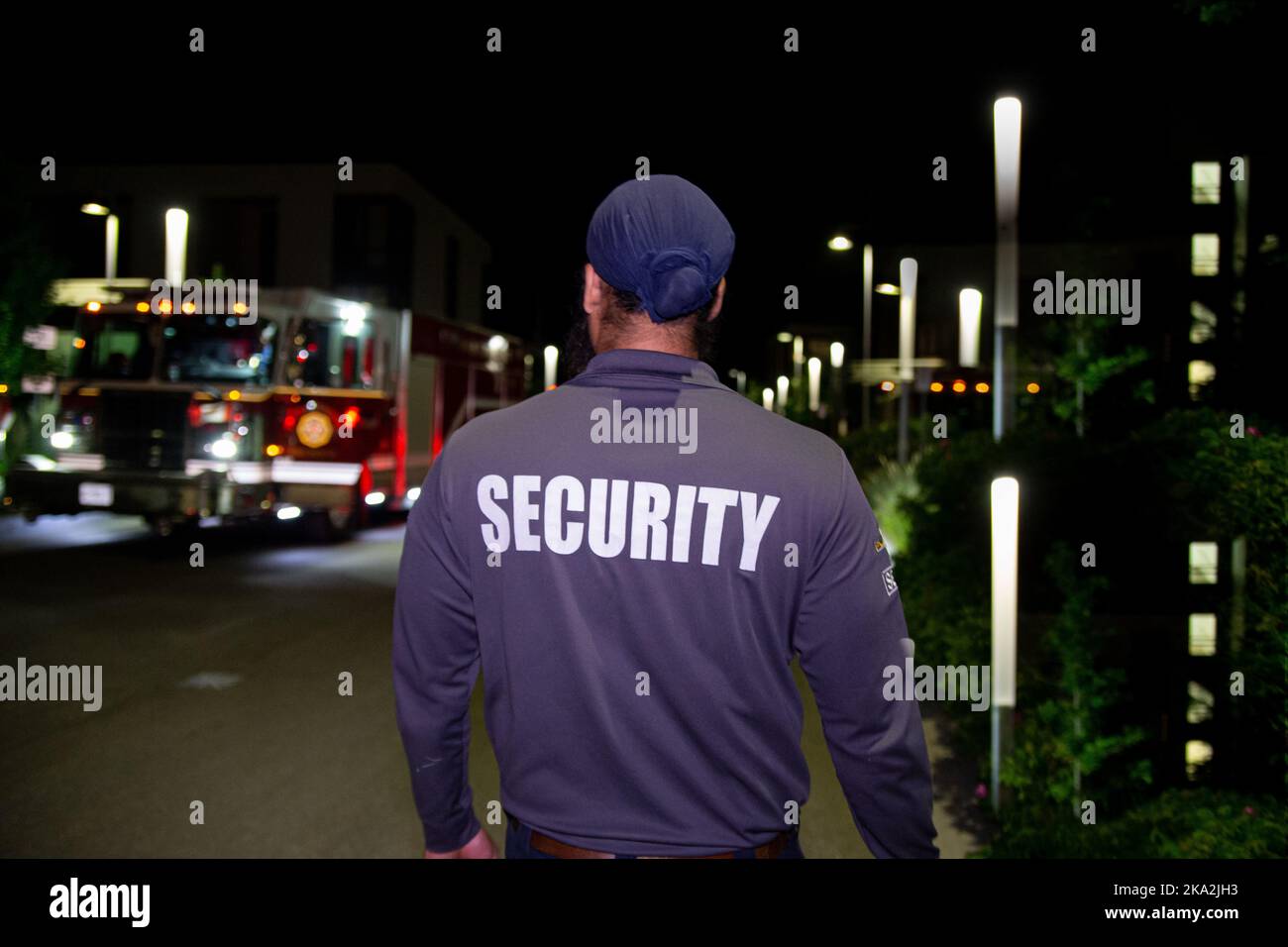 The adult man wearing the blue uniform with the "Security" sign while ...