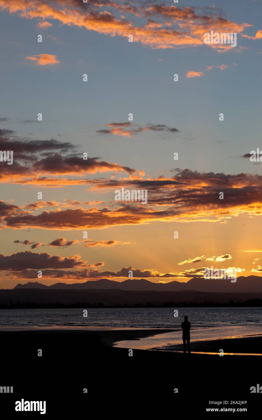 A vertical of a sunset over the beach in Nelson, New Zealand Stock ...