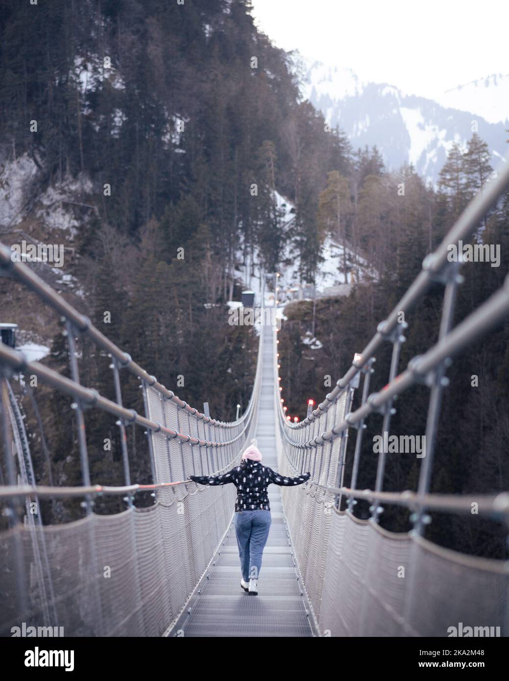 A back view of a woman on Geierlay Suspension Bridge in Sosberg ...