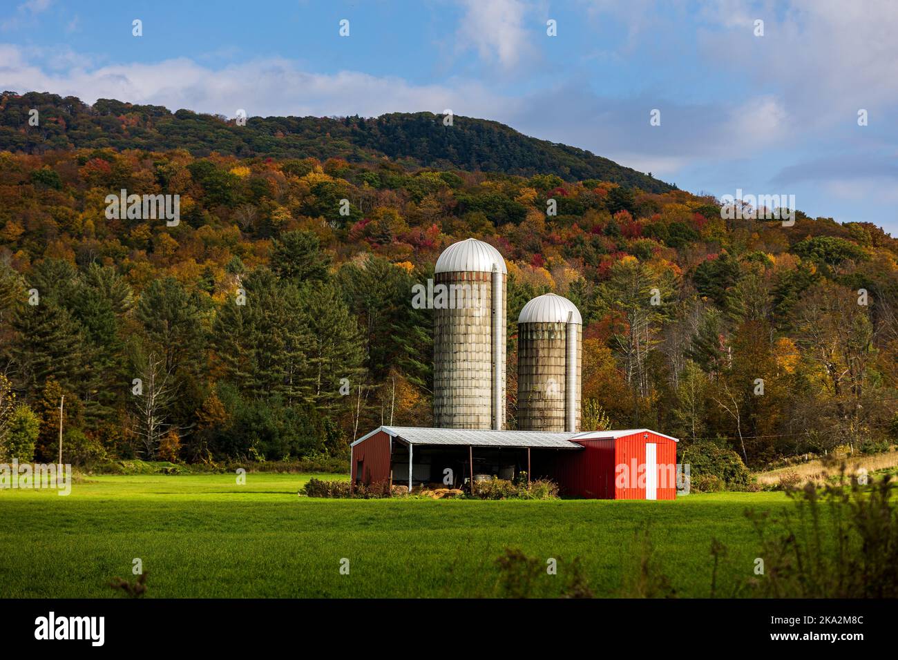 An aerial view of silo towers in background of mountain with dense ...