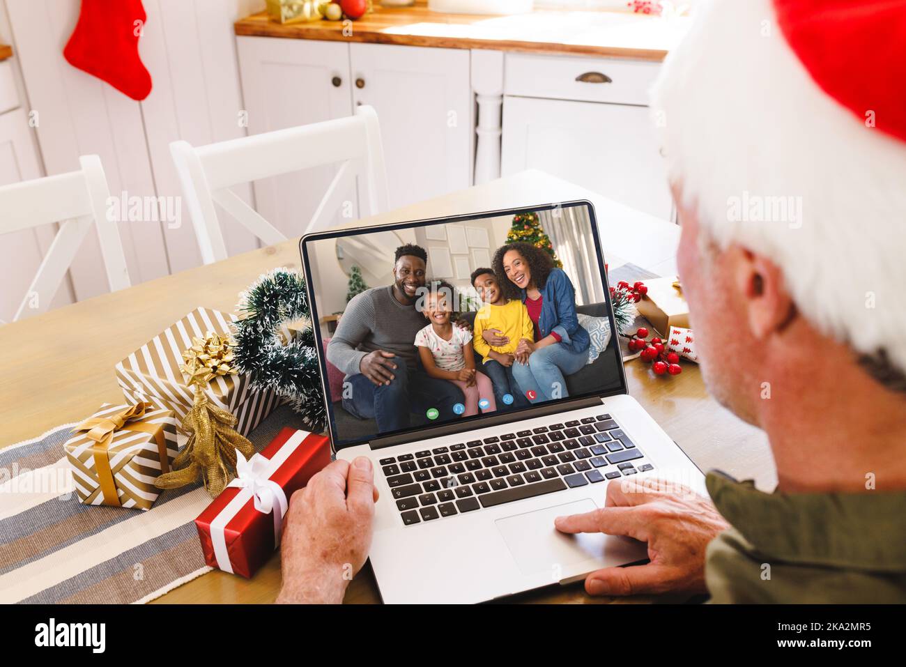 Senior caucasian man having christmas video call with african american ...