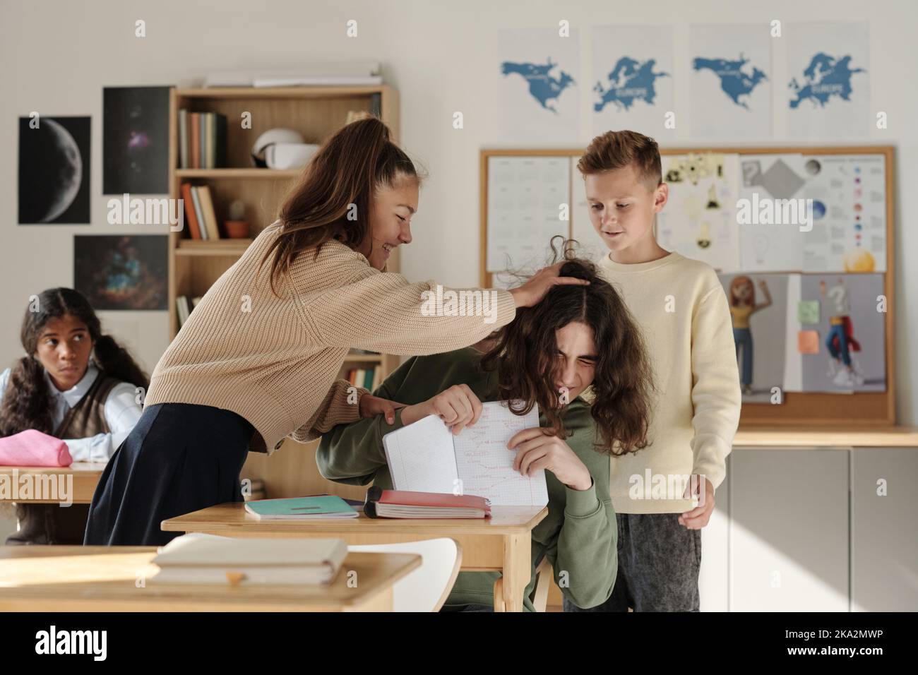 Cruel schoolgirl laughing at classmate and pulling his hair while ...