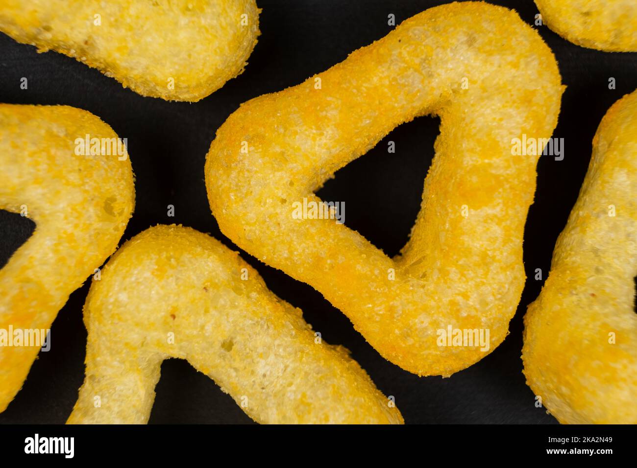 Delicious crispy corn chips triangular shape with spices on a black ...