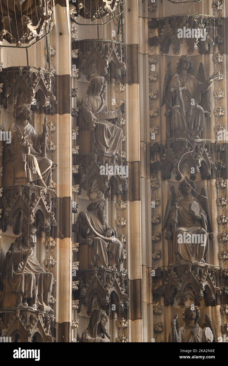 A vertical shot of the facade of the Cologne Cathedral with sculptures ...