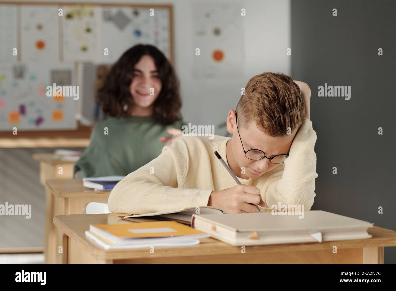 Selective focus on clever and diligent schoolboy making notes in ...