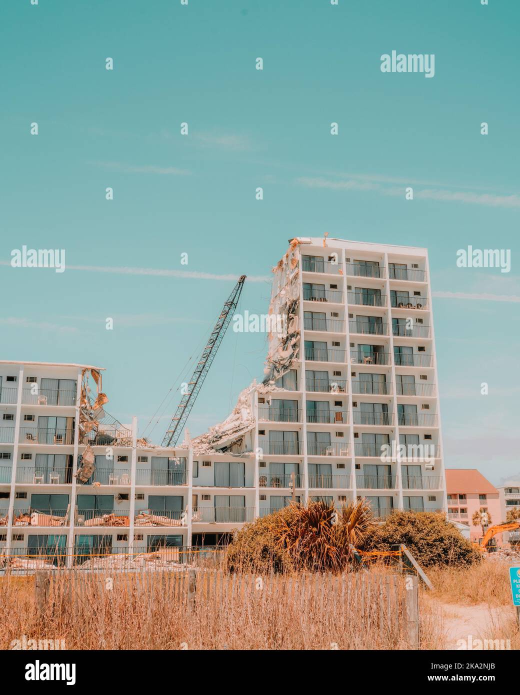 A vertical shot of a demolished broke building under a blue sky Stock ...
