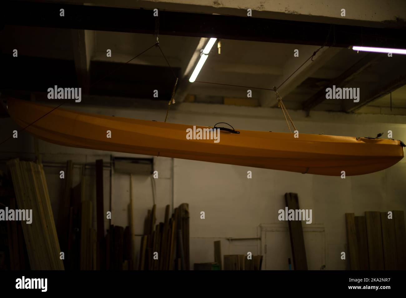 Boat hangs from ceiling. Boat in garage. Yellow water transport. Sports ...