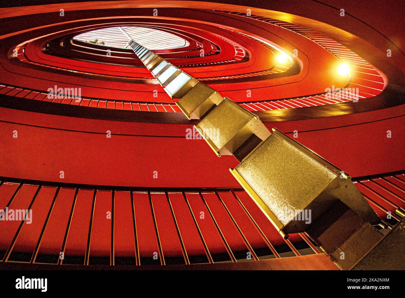 A low angle shot of winding staircase with red railing modern building ...