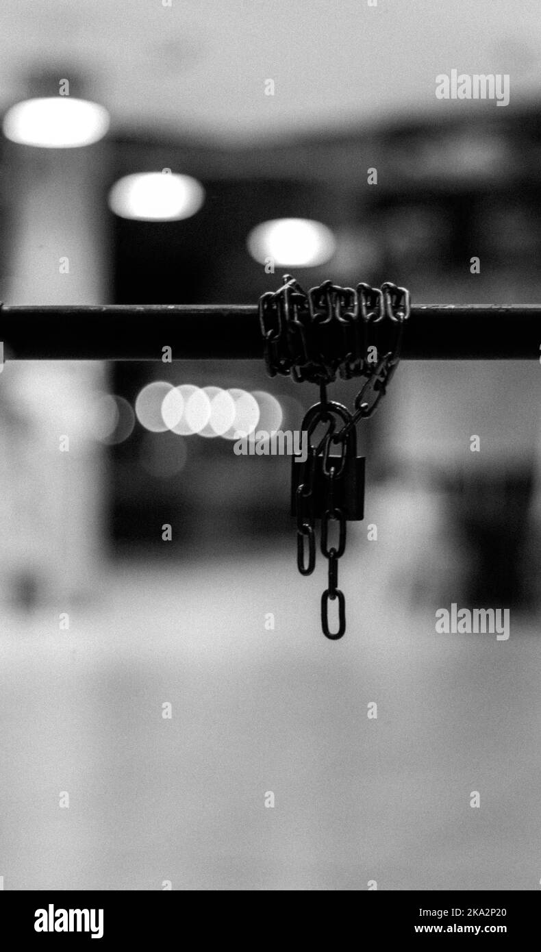 A vertical shot of grayscale chain holding with lock with blur ...
