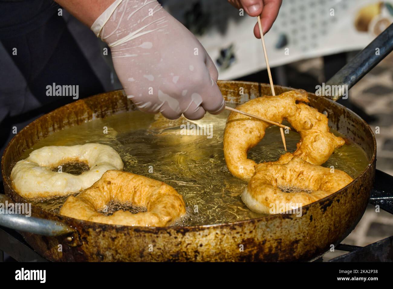 Close up of a worker cooking donuts Stock Photo - Alamy