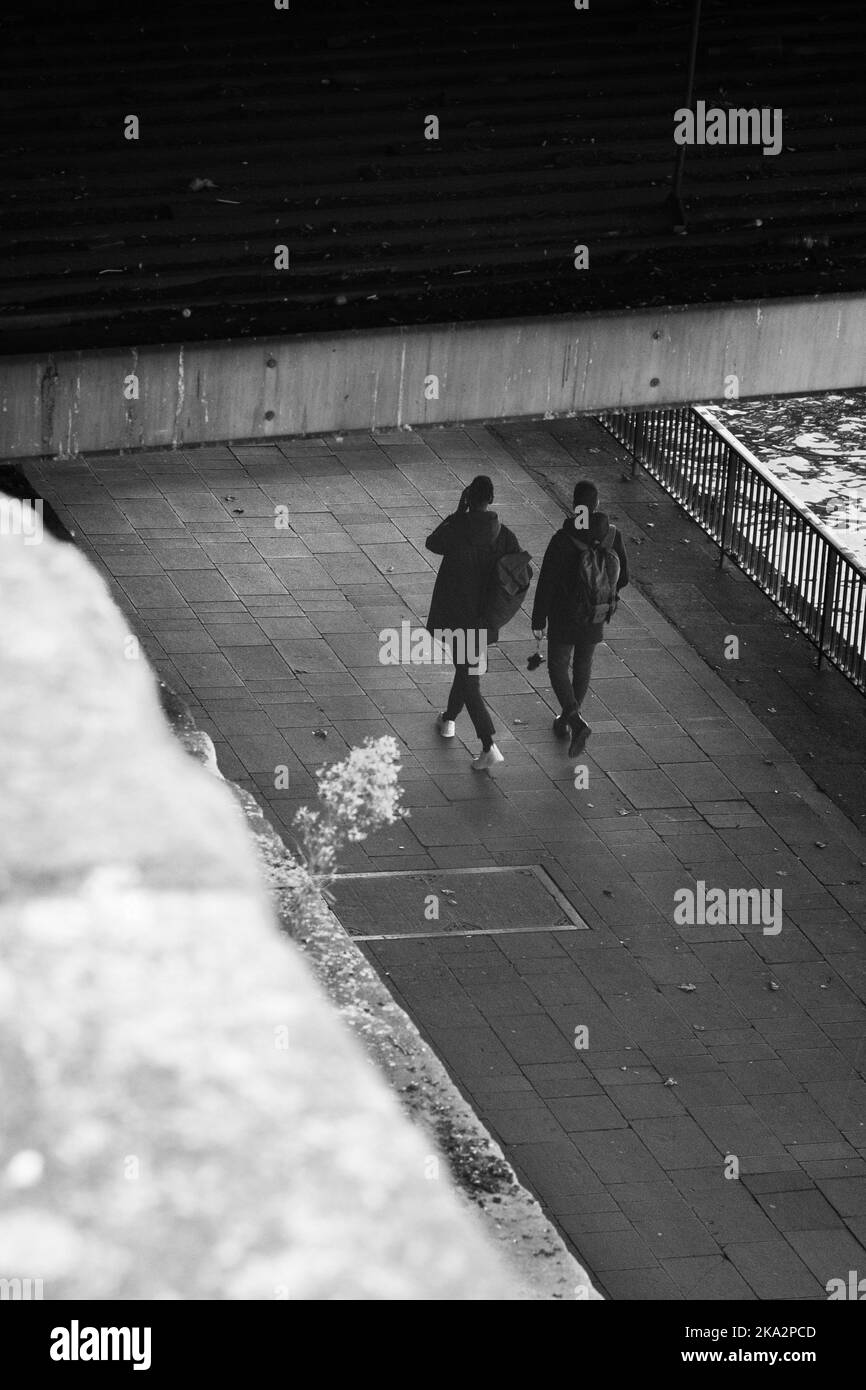 A grayscale rooftop view of two people walking under Hohenzollern ...