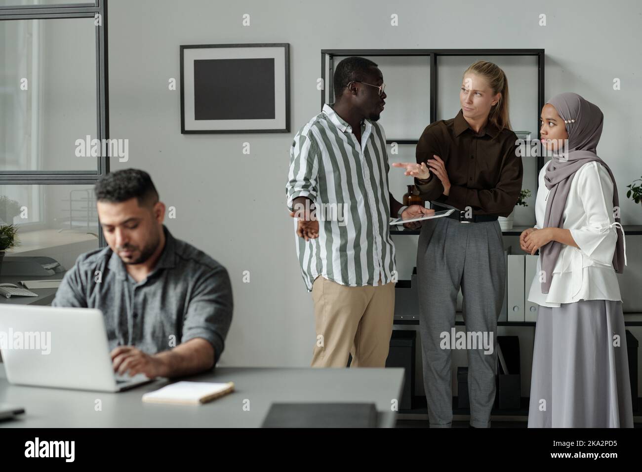 Group of young multicultural colleagues talking about Hispanic male ...