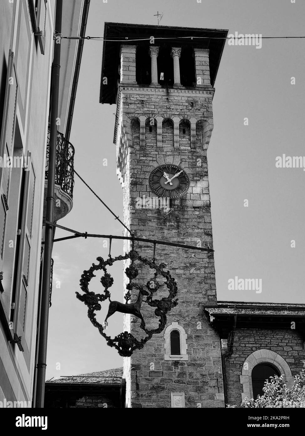 A vertical grayscale view of a stone clock tower in Bellinzona ...