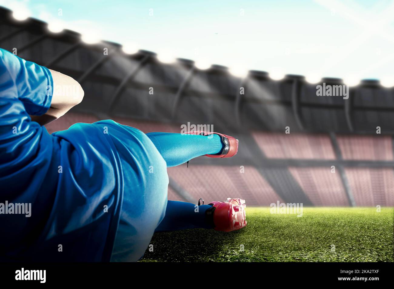 Rear view of a football player man in a blue jersey tackling the ball ...