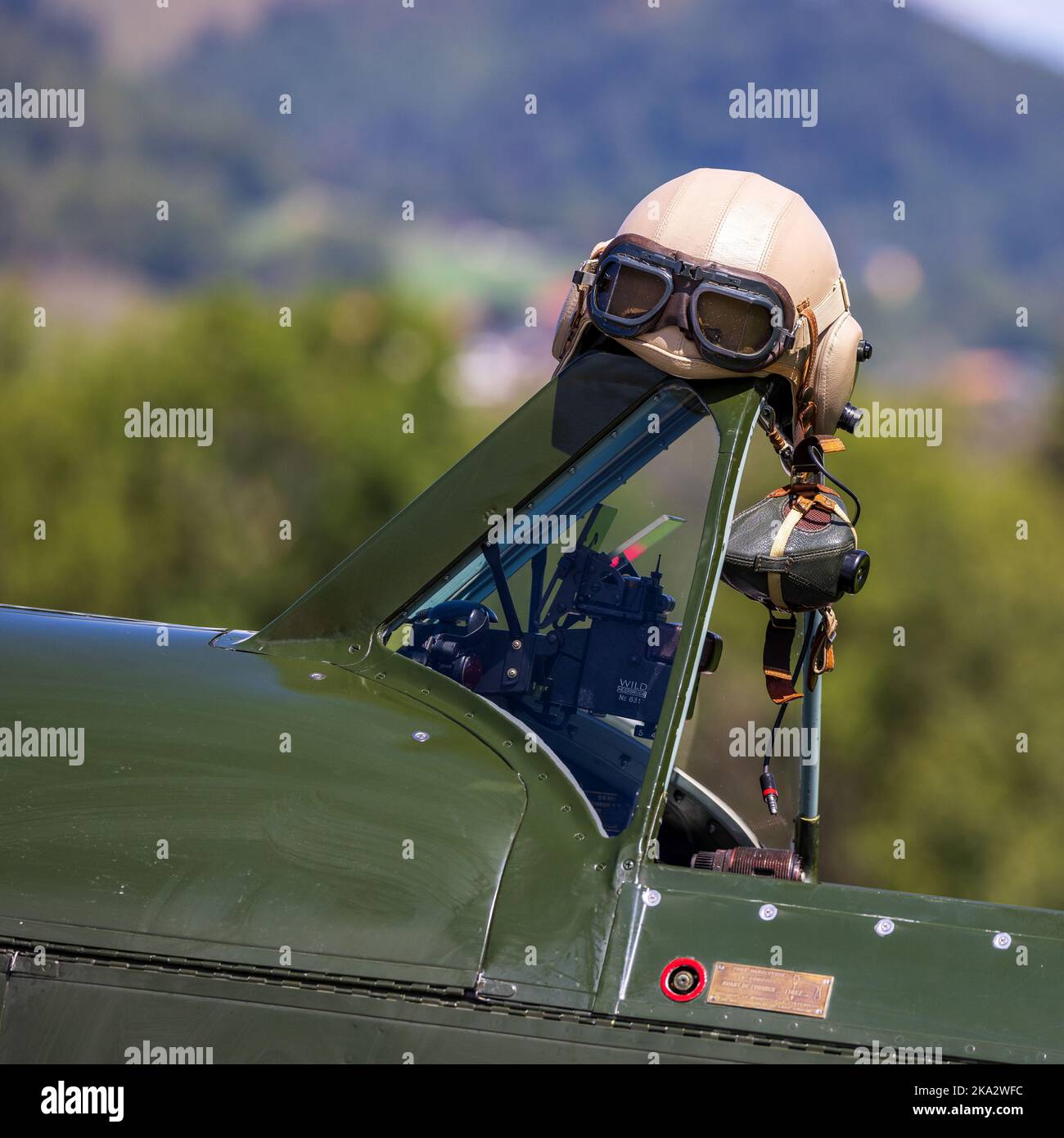 The close-up view of a vintage flight helmet hanging over a navy ...