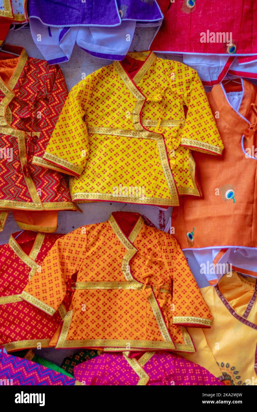 A vertical shot of traditional Indian boy clothing hanging from a wall ...