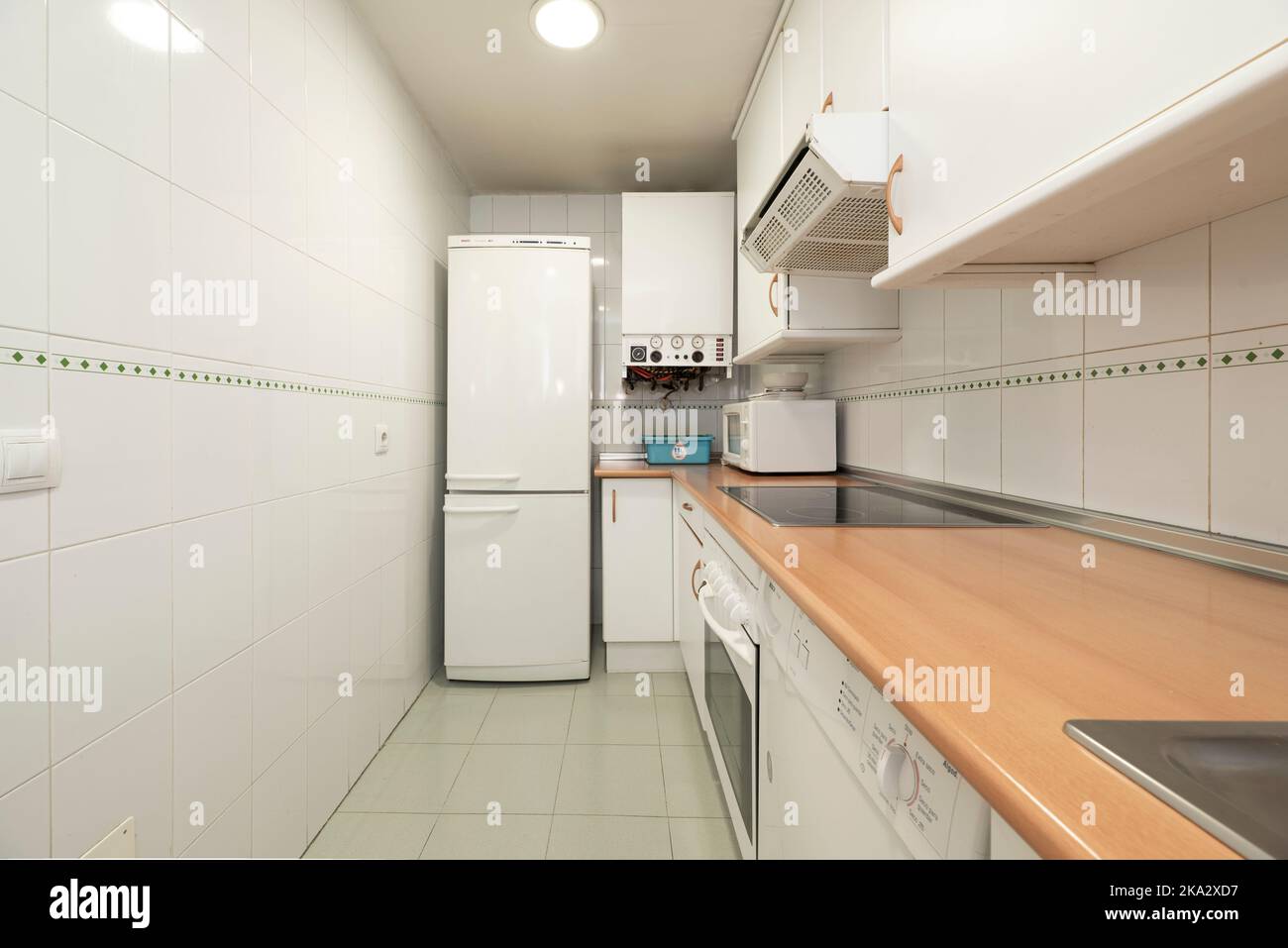 elongated kitchen room with white cabinets with matching appliances and ...