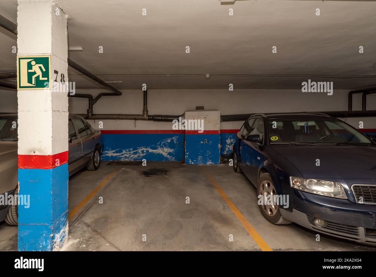 Garage space flanked by several vehicles on the ground floor of a ...