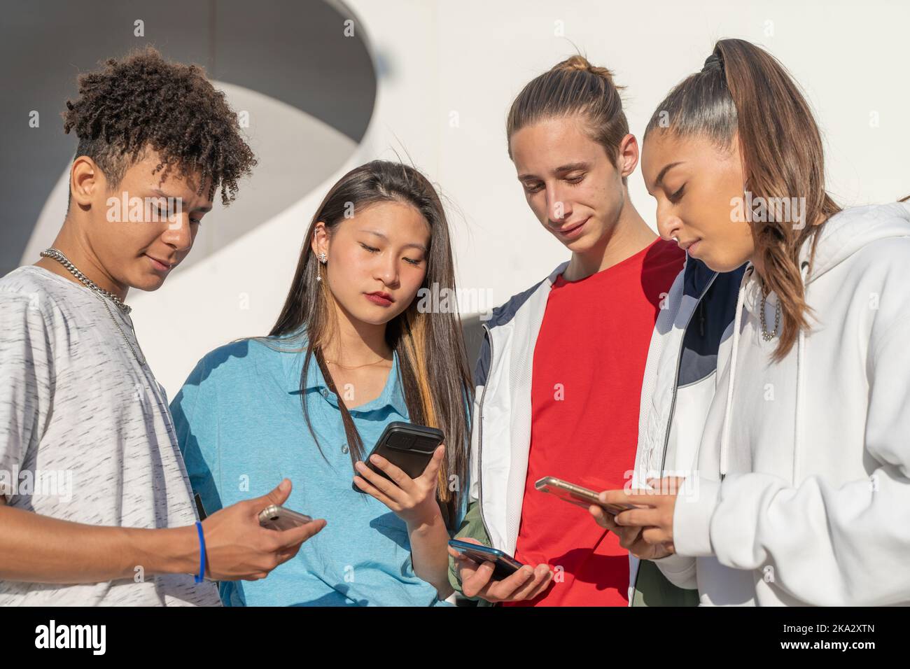 Group of friends looking their phones abducted with out paying attention to their colleagues ...