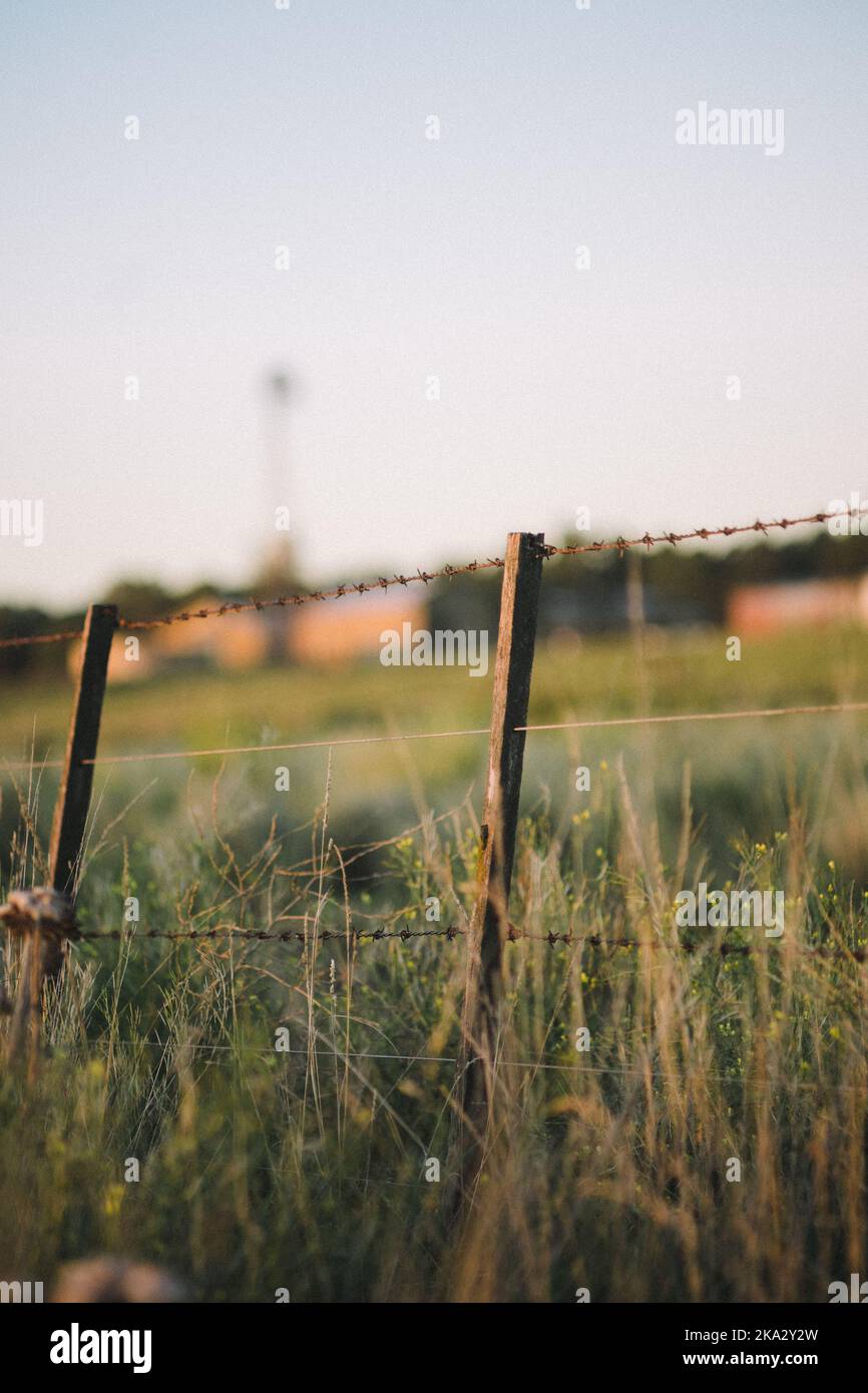 A rural scene with a barbed fence in agricultural field Stock Photo - Alamy
