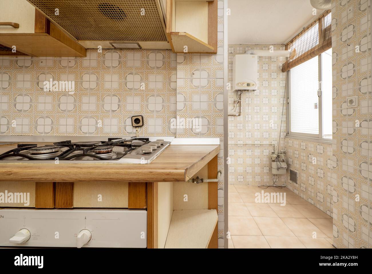 Corner of an old kitchen with dirty wooden cabinets and matching ...
