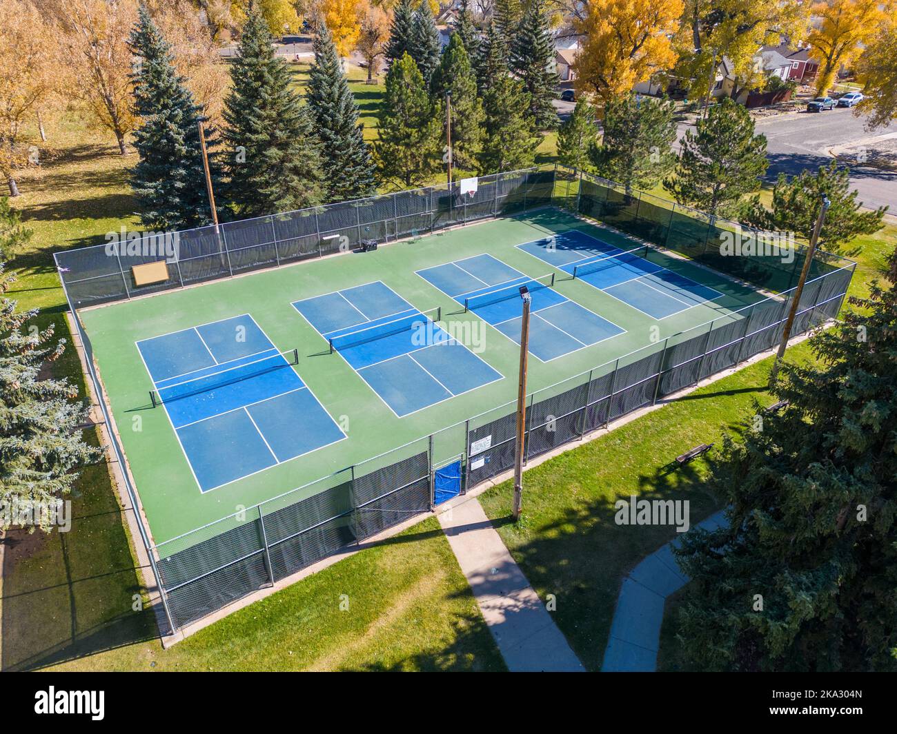A side view of Laramie Wyoming Tennis Court in a City Park surrounded ...