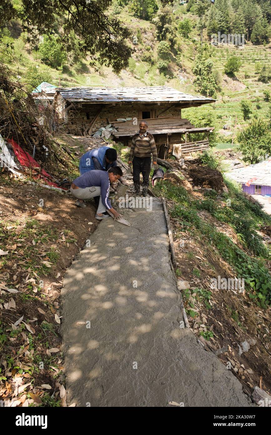 A vertical shot of the villagers paving a path in a remote mountain ...