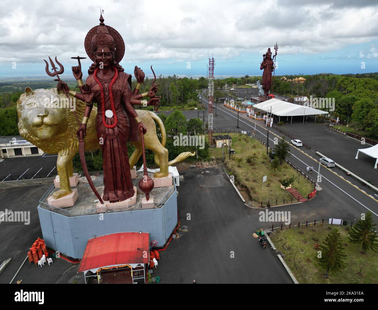 An aerial view of the Ganga Talao temple in India with a statue, trees ...