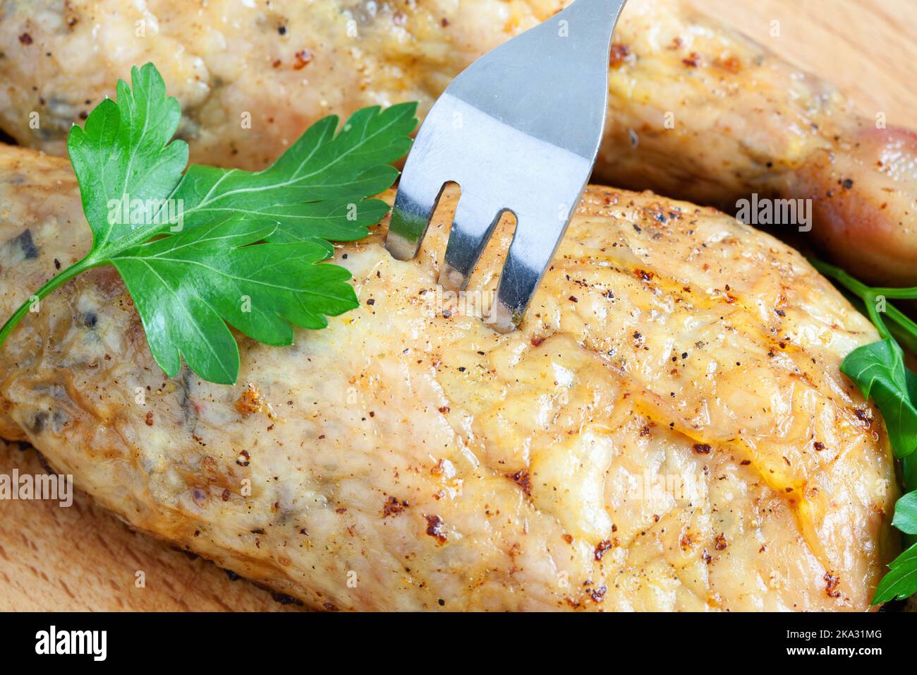 Pierce the chicken with a fork on a cutting board Stock Photo - Alamy