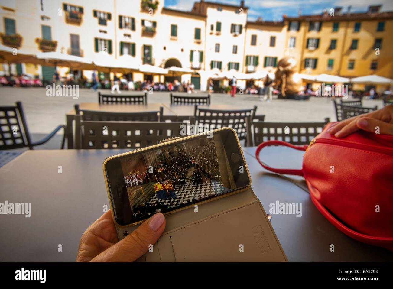 Funeral of Queen Elizabeth II seen on mobile phone in Lucca Tuscany ...