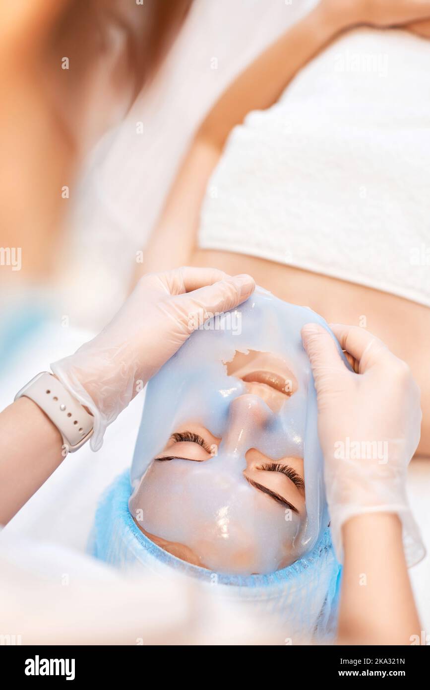 beautician removing mask from face of beautiful woman Stock Photo - Alamy