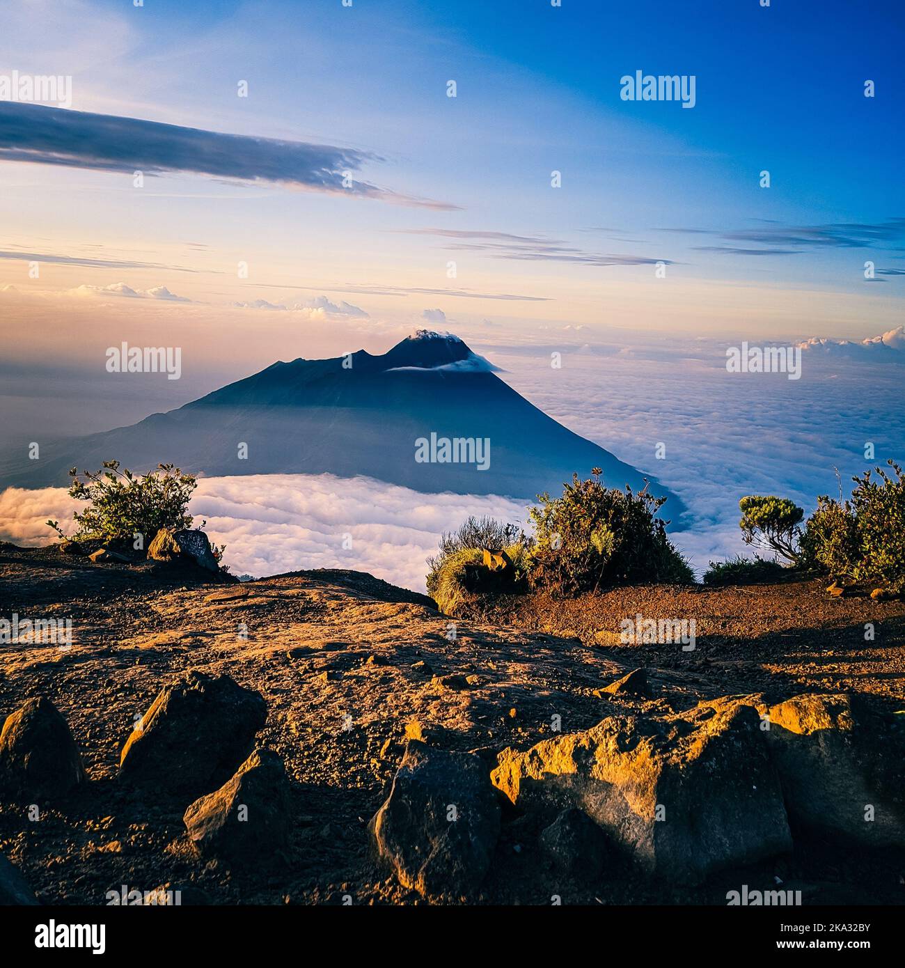 A view of a beautiful volcano at sunrise with clouds around it and a ...