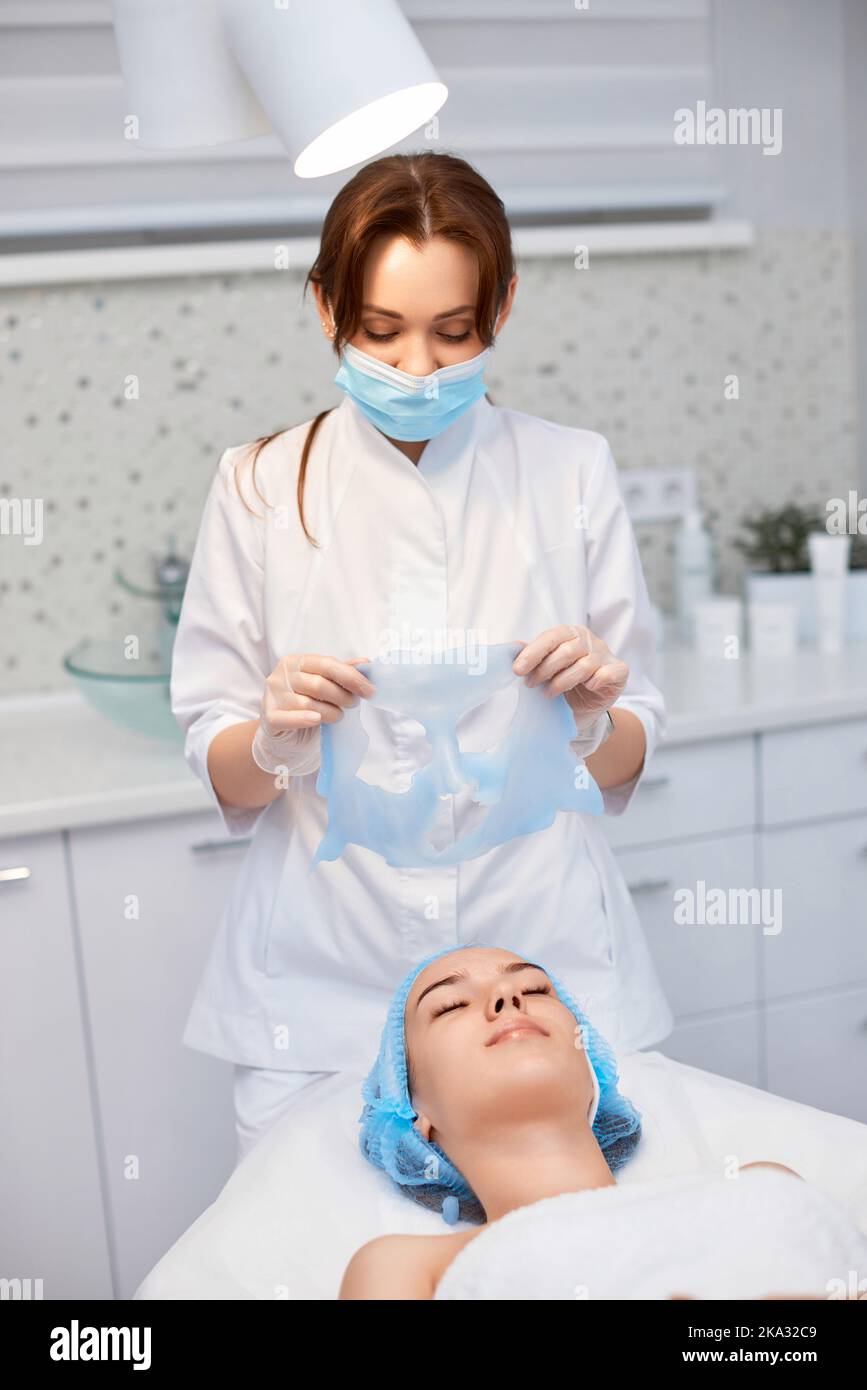 beautician removing mask from face of beautiful woman Stock Photo - Alamy