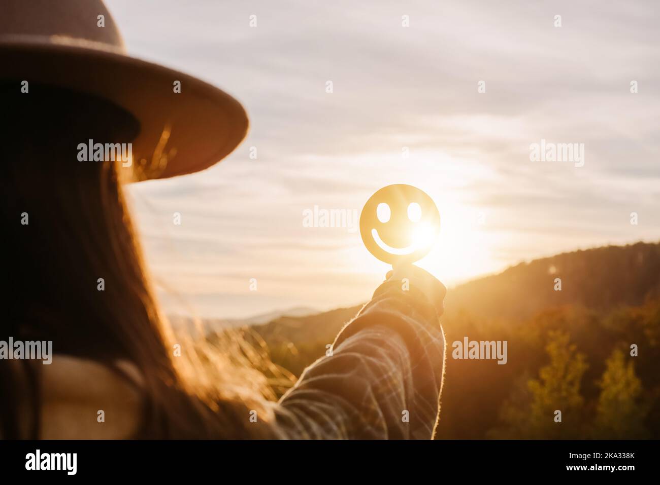 Side view of young female holding happy smile face on background ...