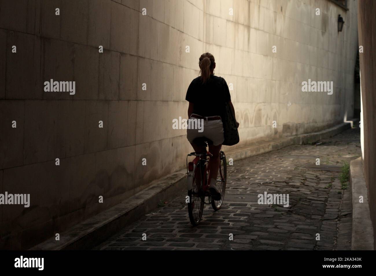 A back view of a female cycling on a street in Le Marais, Paris Stock ...