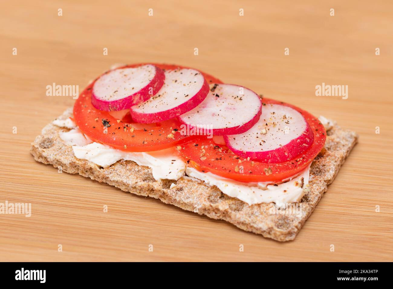 Whole Grain Crispbread with Tomato, Cream Cheese and Radish on Bamboo ...