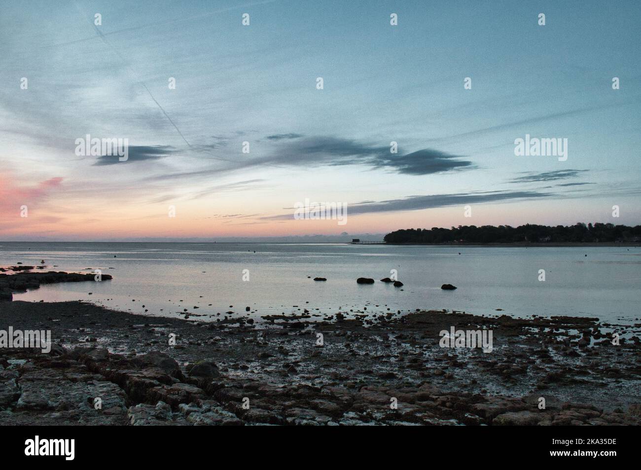 An early morning sunrise scene of a beach on a calm day Stock Photo - Alamy