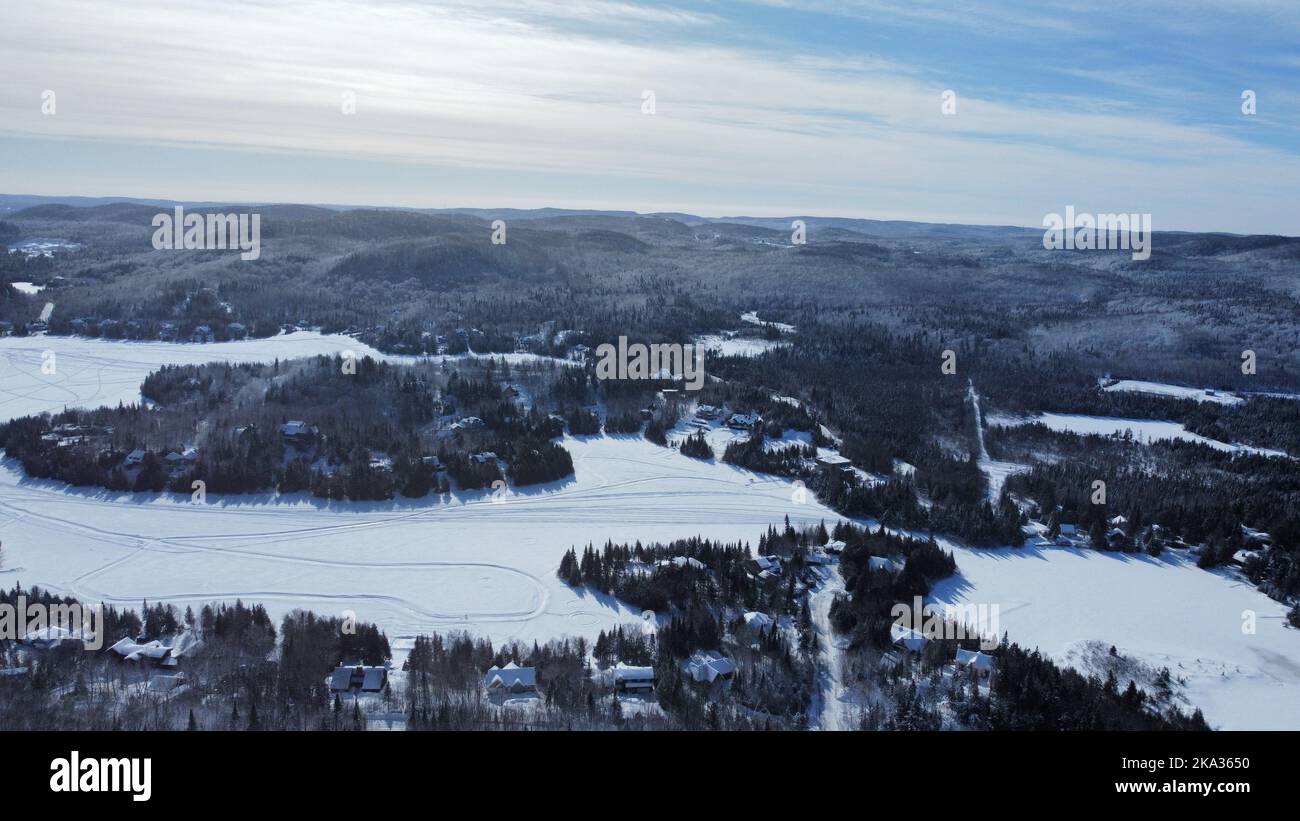 An aerial view of a landscape with forest and fields covered in snow ...