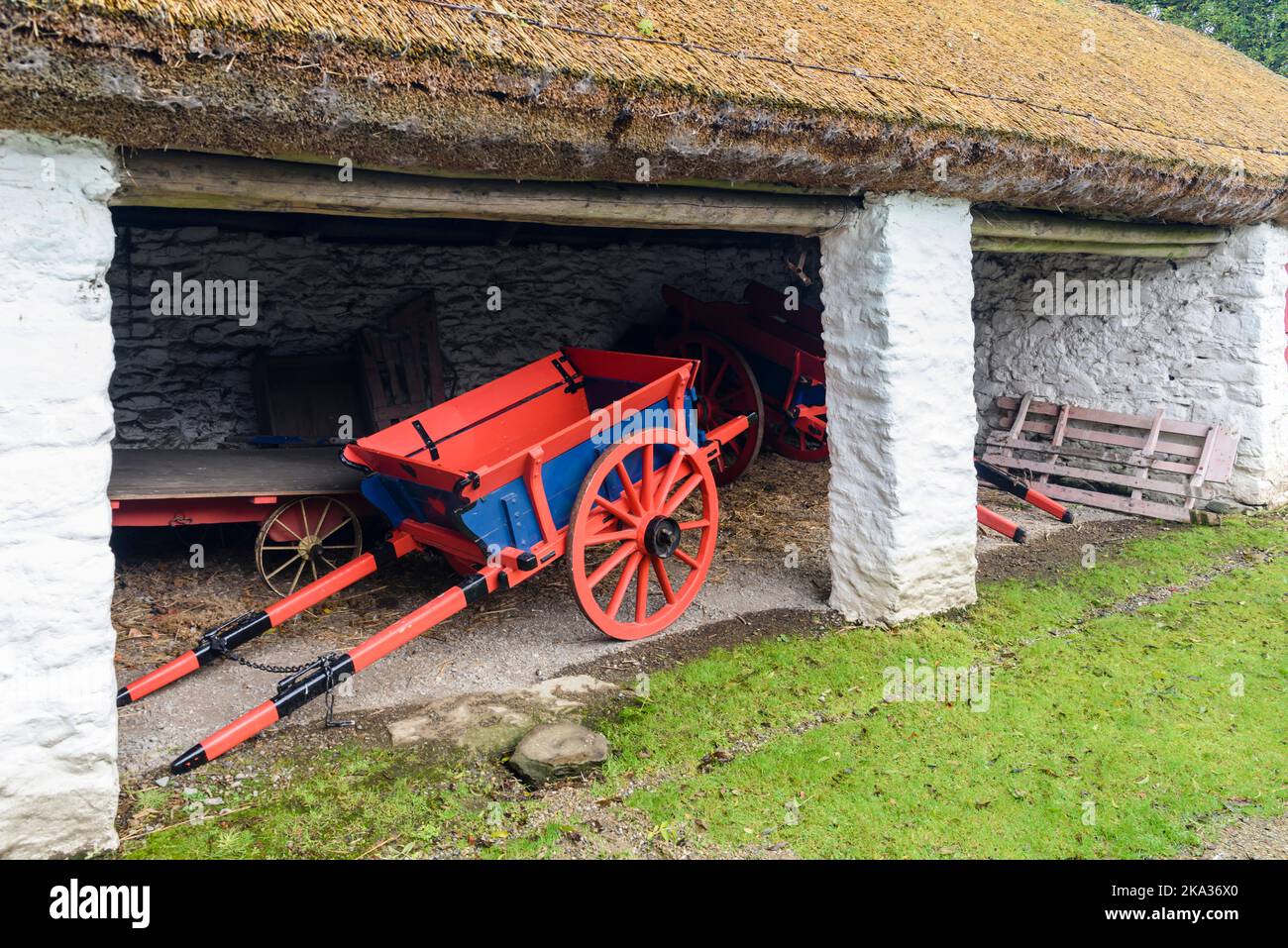 Red and blue painted horse drawn cart in a farm byre Stock Photo - Alamy