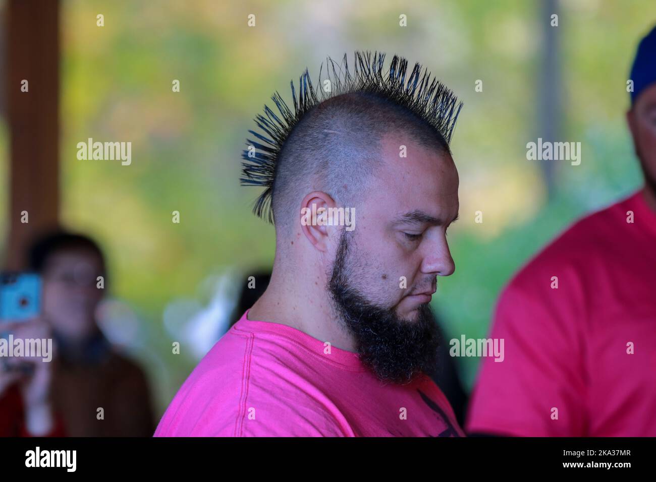 The man with a mohawk hairstyle wearing a pink shirt at a weightlifting ...
