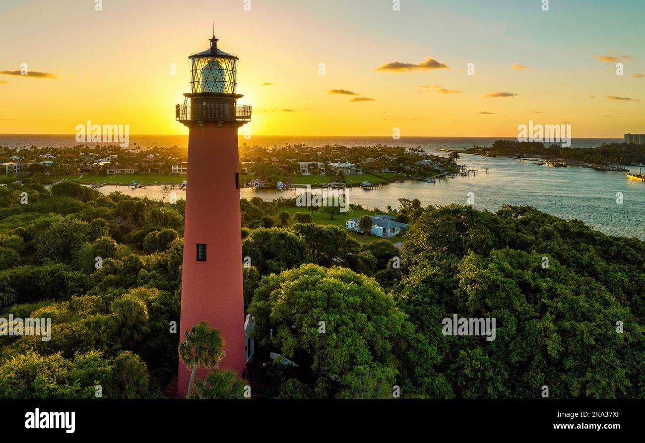 A pink lighthouse in a forest by the sea during a sunset Stock Photo ...