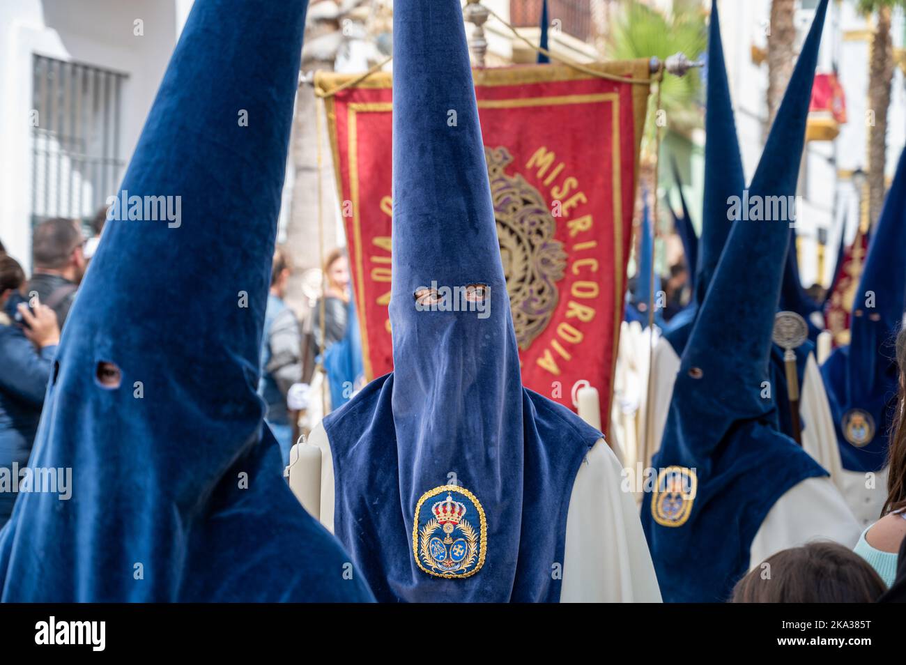 People wearing traditional capirote conical pointed hats in an easter ...