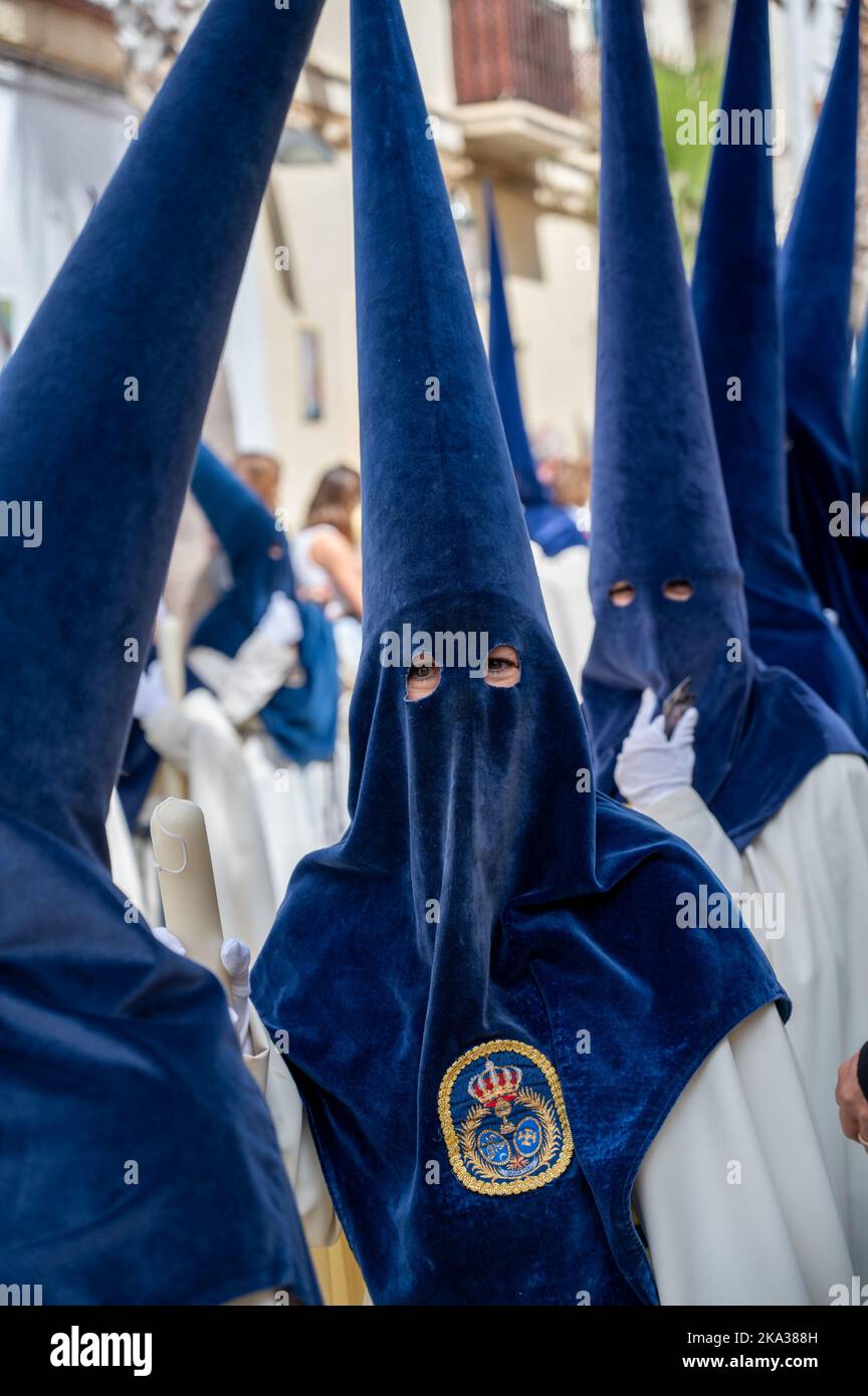 People wearing traditional capirote conical pointed hats in an easter ...