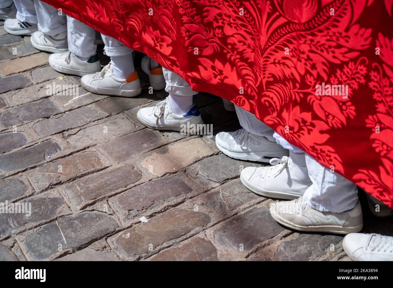 The feet of people carrying a heavy throne in an Easter Parade during ...
