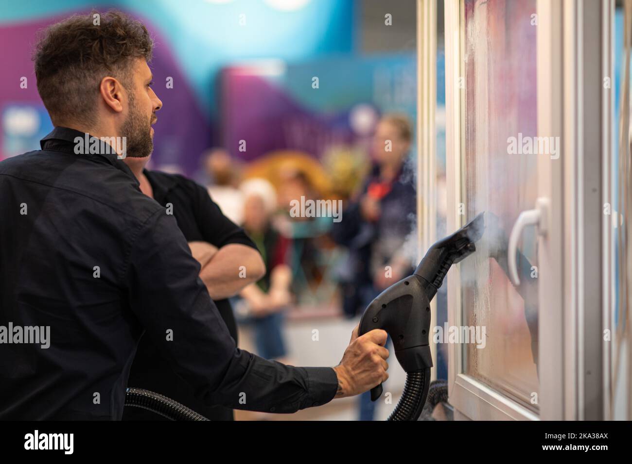 A guy testing a window cleaner at BEA Expo in Bern, Switzerland Stock ...