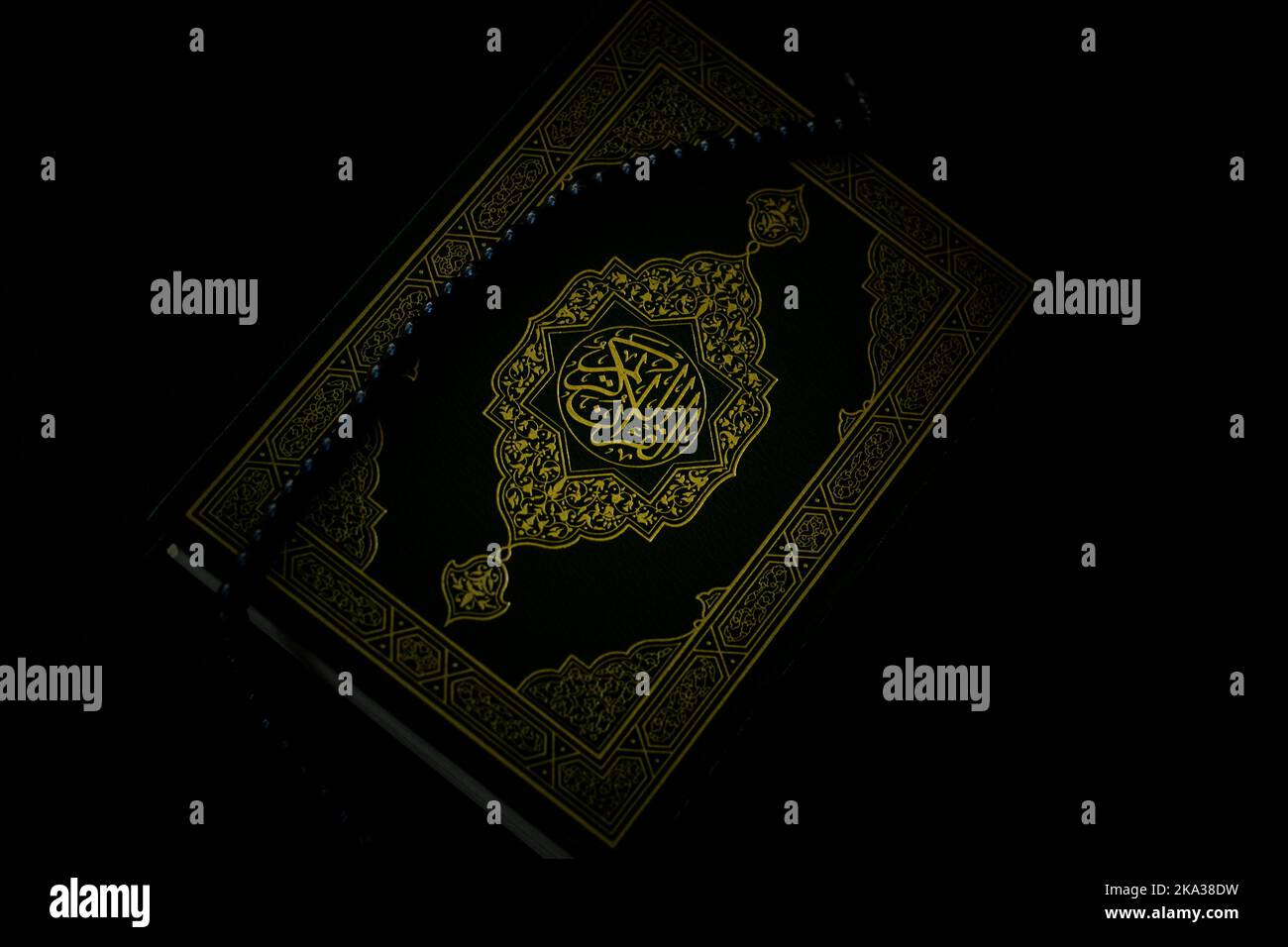 A closeup shot of the gold Al-Quran holy book sign on a black ...